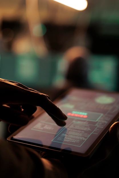 Afroamerykanin haker trzyma tablet, aby włamać się do systemu online ... Afroamerykanin haker trzyma tablet, aby włamać się do systemu online ...