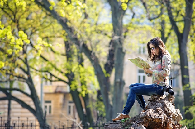Niña Sentada En El Parque Y Leyendo Un Mapa Foto Premium