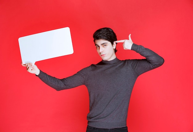 Homem segurando uma ideia retangular e fazendo um brainstorming | Foto ... Homem segurando uma ideia retangular e fazendo um brainstorming | Foto ...