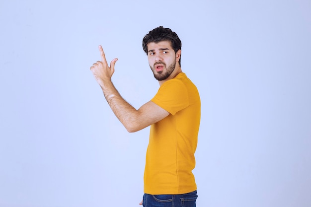 Mann hebt seine hand und zeigt auf etwas oben. | Kostenlose Foto Mann hebt seine hand und zeigt auf etwas oben. | Kostenlose Foto