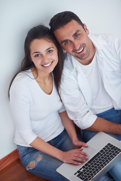 Feliz jovem casal relaxado trabalhando no computador portátil no ... Feliz jovem casal relaxado trabalhando no computador portátil no ...