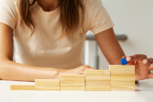 Mano de mujer arreglando el apilamiento de bloques de madera como ... Mano de mujer arreglando el apilamiento de bloques de madera como ...