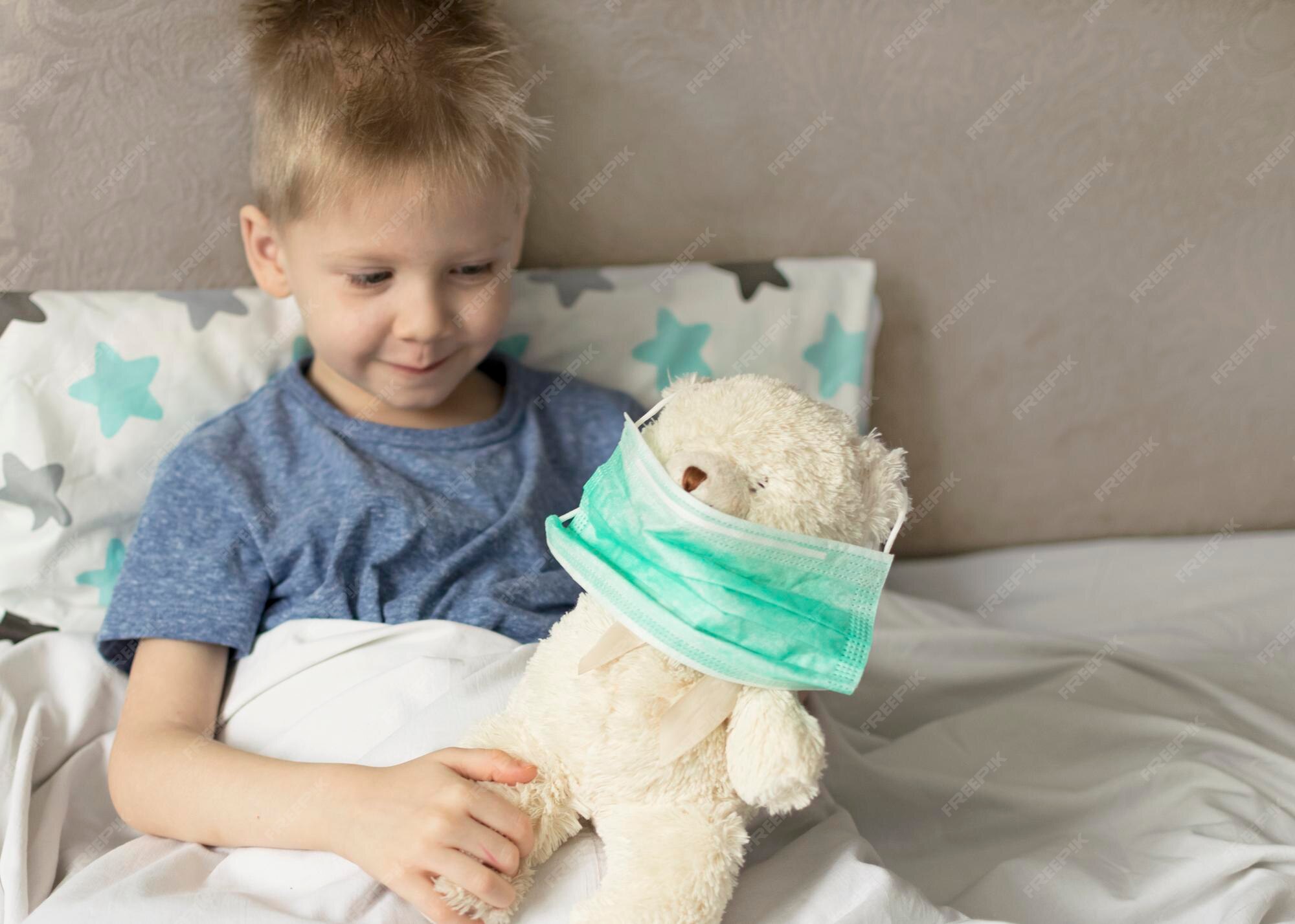 Uma Criança Triste E Doente Com Febre E Dor De Cabeça Está Na Cama Com Um Ursinho De Brinquedo