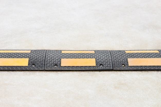 Premium Photo | Black speed bump on the road close-up, speed limit Premium Photo | Black speed bump on the road close-up, speed limit