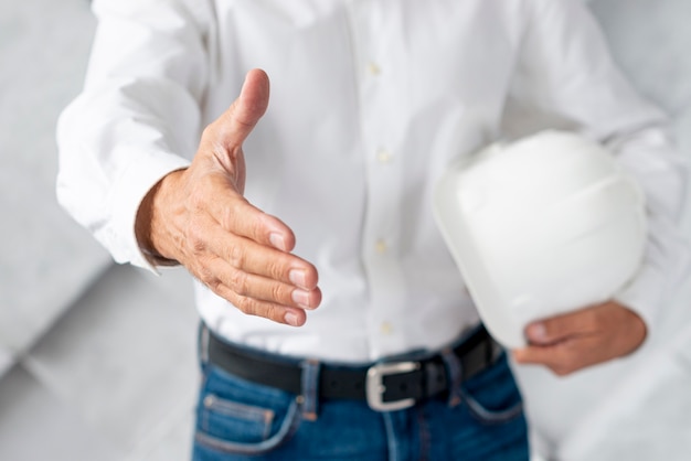 Premium Photo | Close-up architect giving a hand shake Premium Photo | Close-up architect giving a hand shake