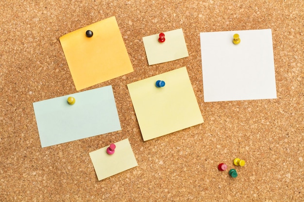 Premium Photo | Colored sticky notes hanging on a cork board Premium Photo | Colored sticky notes hanging on a cork board