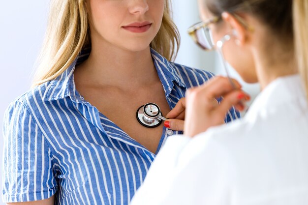 Premium Photo Female Doctor Checking Patient Heartbeat Using Stethoscope