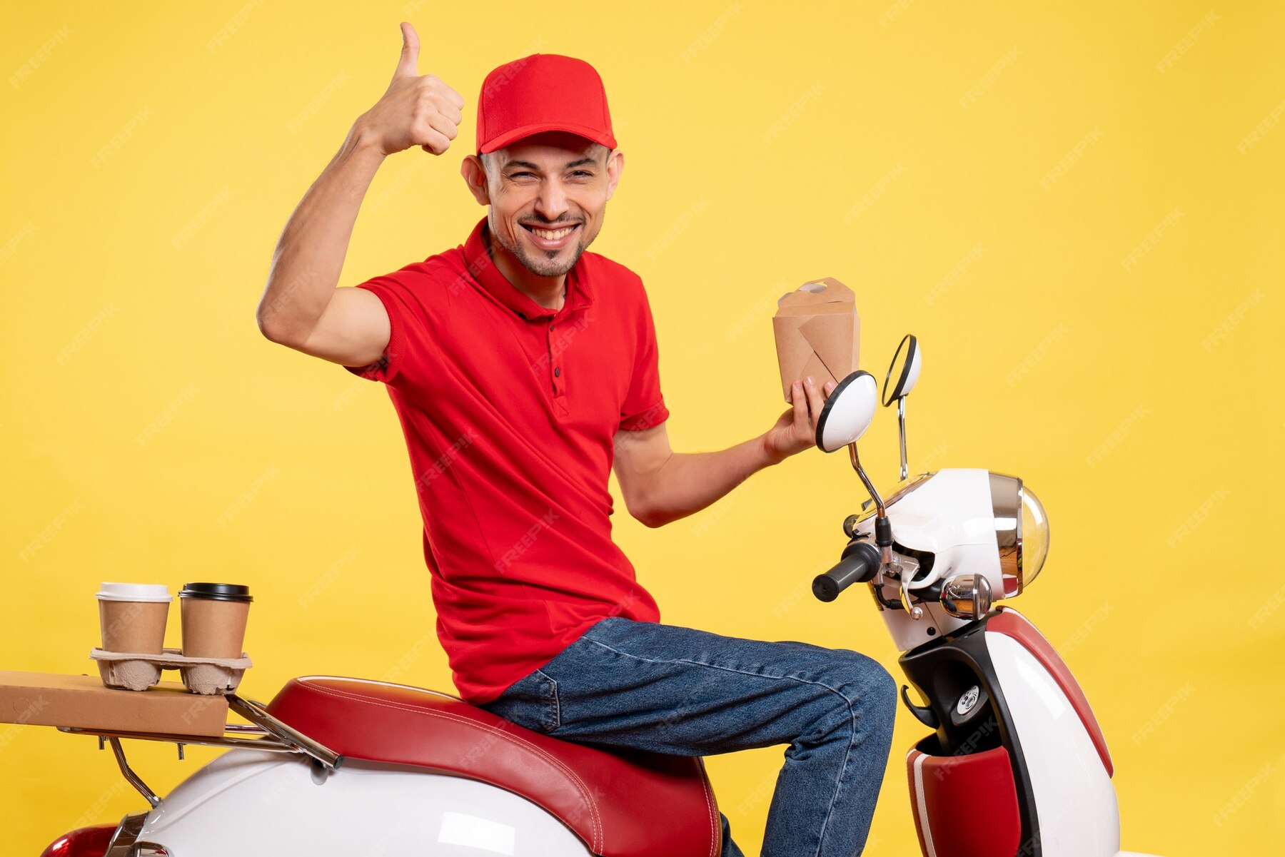 Free Photo Front View Young Male Courier In Red Uniform Holding