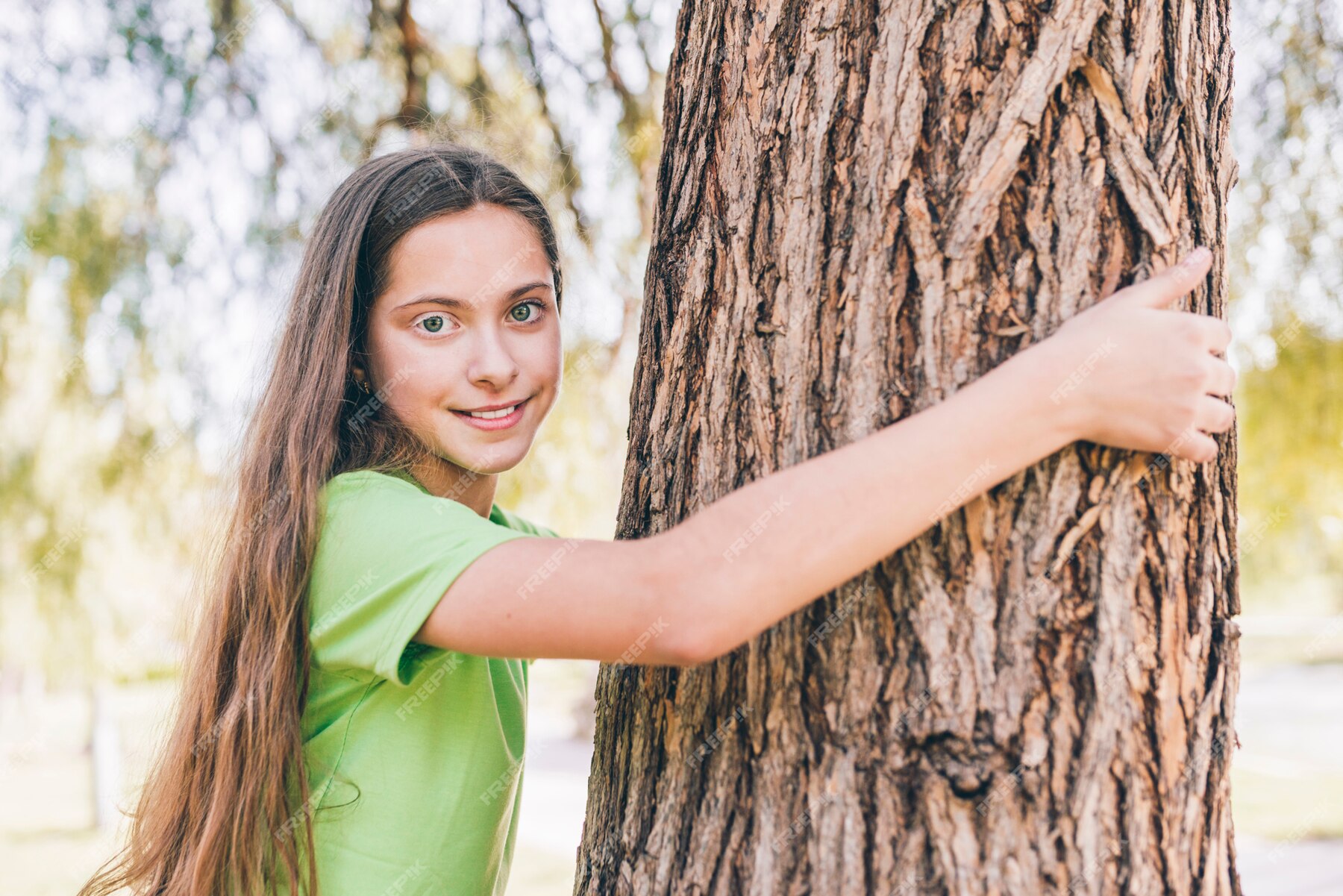 Free Photo Portrait Of A Smiling Girl Embracing Tree Trunk