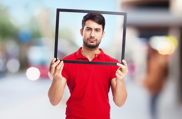 Free Photo | Sad guy holding a black frame Free Photo | Sad guy holding a black frame