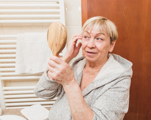 Premium Photo | Senior woman touching her soft face skin and looking in ... Premium Photo | Senior woman touching her soft face skin and looking in ...