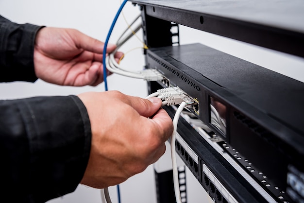 Premium Photo | Technician connecting network cables to switches ... Premium Photo | Technician connecting network cables to switches ...