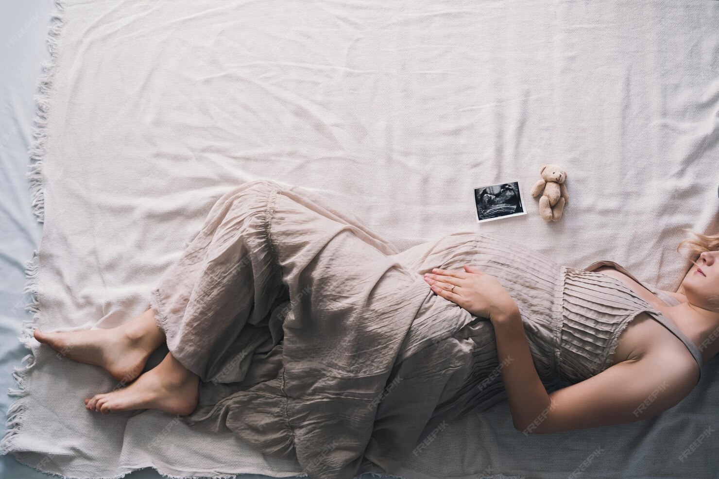 Belle Femme Enceinte En Robe Tenant Les Mains Sur Le Ventre Allongée Sur Le Côté En Profil Dans