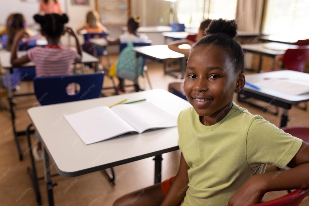 Portrait d'une écolière afro-américaine heureuse dans une classe d ... Portrait d'une écolière afro-américaine heureuse dans une classe d ...