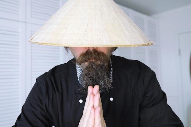 あごひげを生やしたベトナムの帽子をかぶったアジア人男性の陽気なパロディーportraitasiancafe Chef プレミアム写真