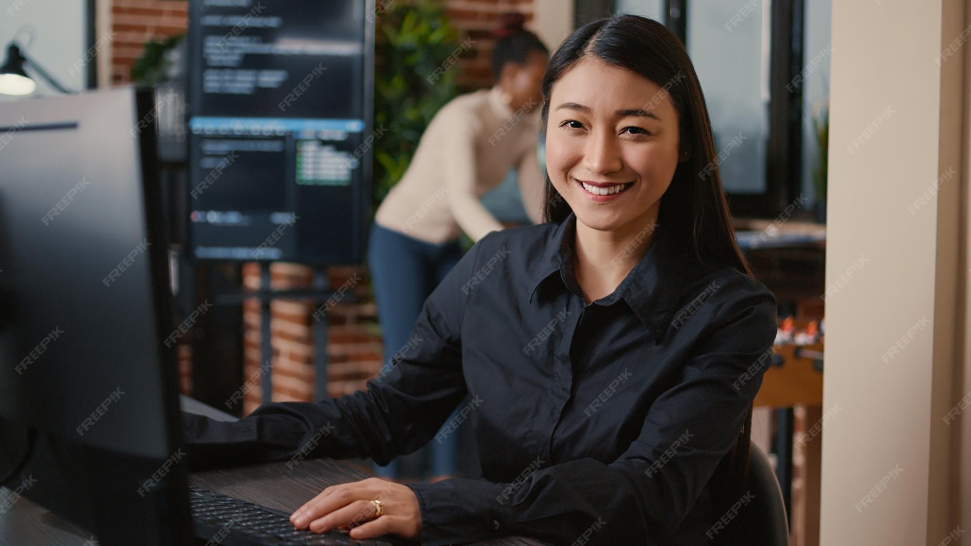 Premium Photo | Asian software developer smiling and resuming work typing code on computer ...