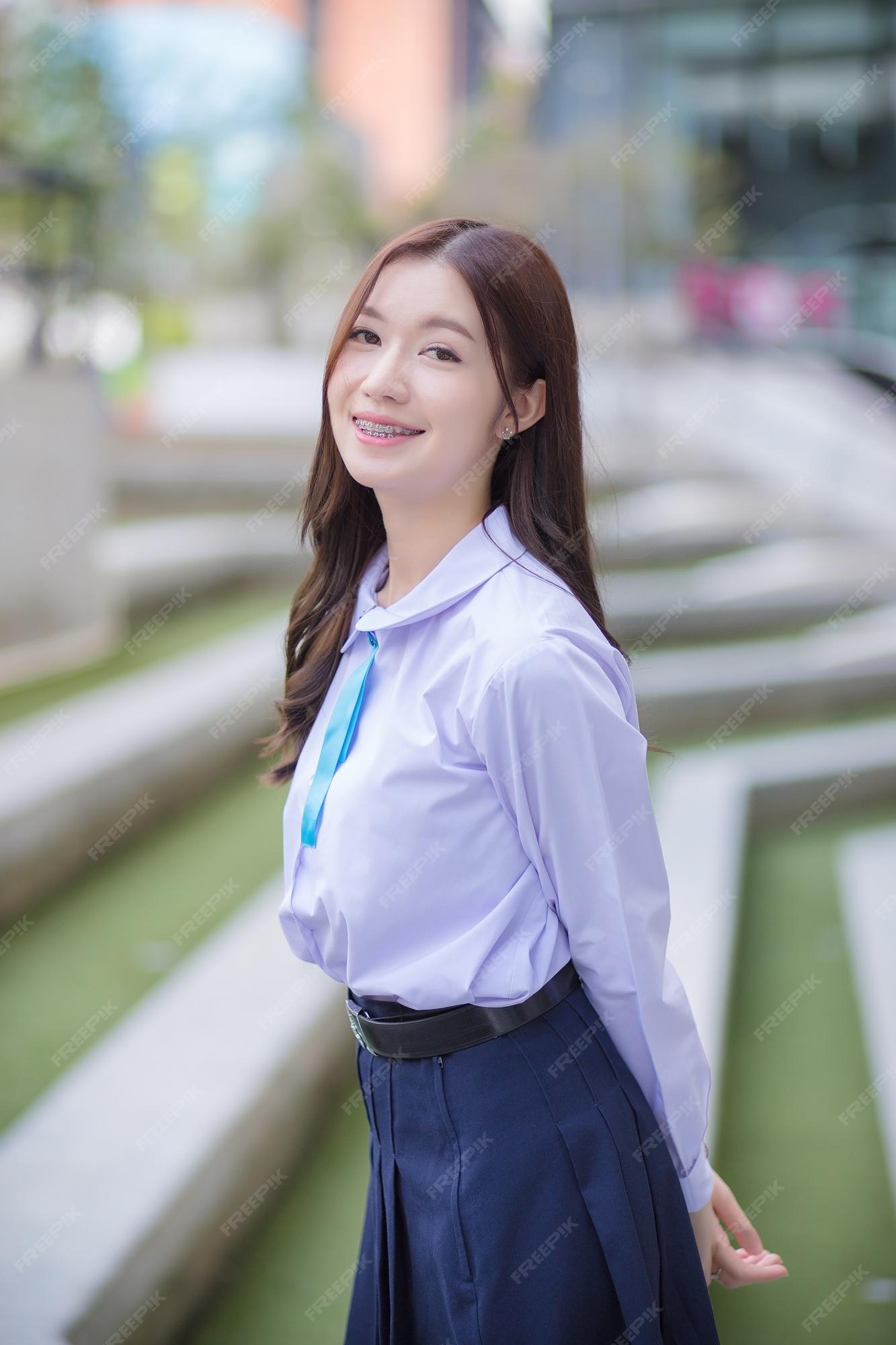 그녀의 치아에 교정기와 교복에 아름 다운 아시아 고등학생 소녀 프리미엄 사진