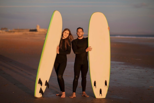Premium Photo Beautiful Surfers Couple With Two Surfboards Posing On