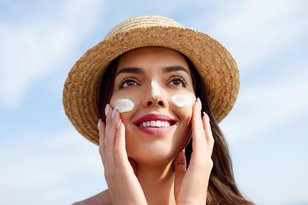 Premium Photo Beautiful Woman Applying Cream Sunscreen On Tanned Face