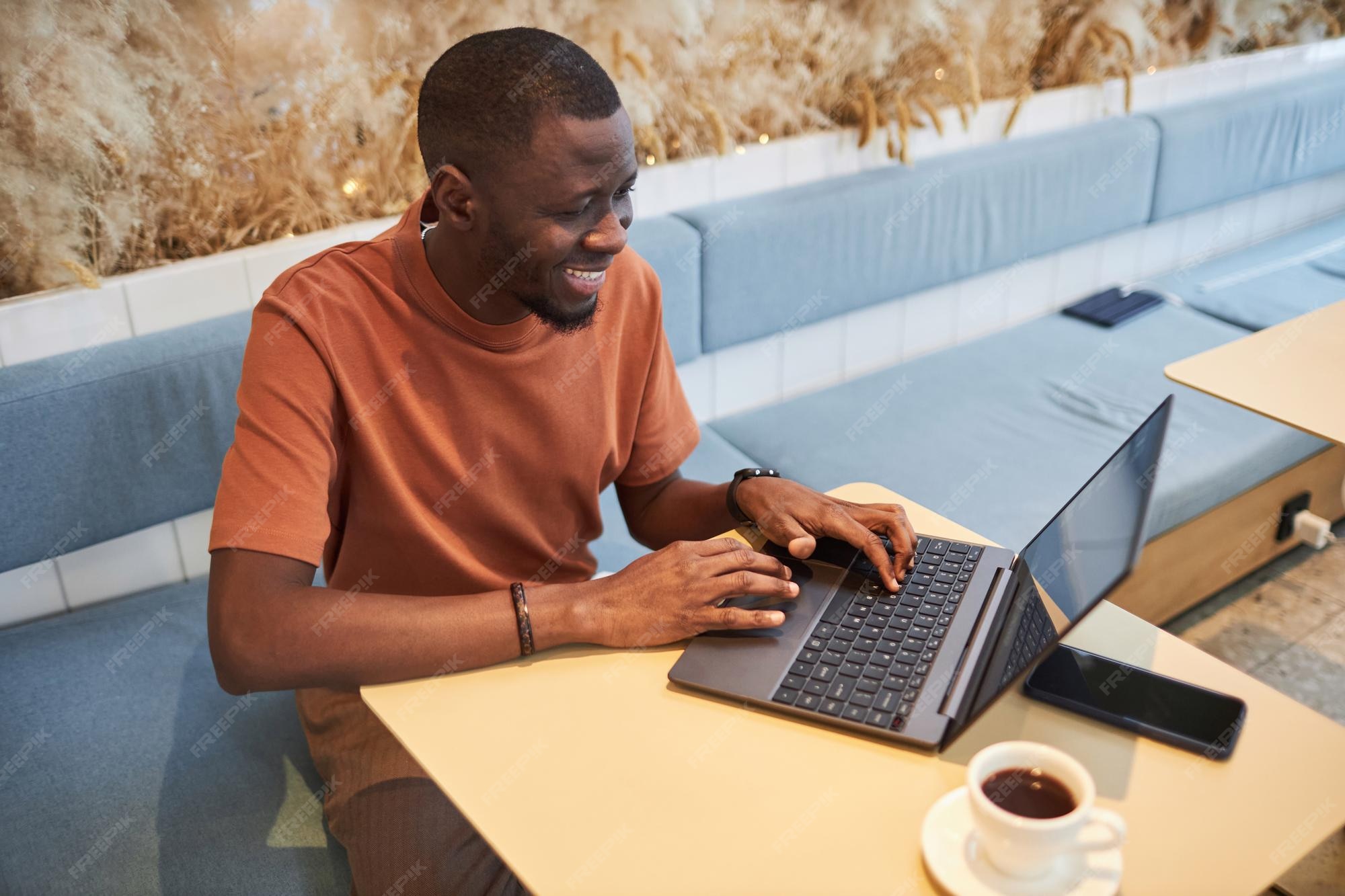 Premium Photo | Black man using laptop in coffee shop and typing Premium Photo | Black man using laptop in coffee shop and typing