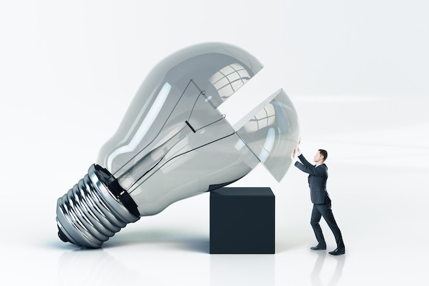 Premium Photo | Businessman pushes a big light bulb Premium Photo | Businessman pushes a big light bulb