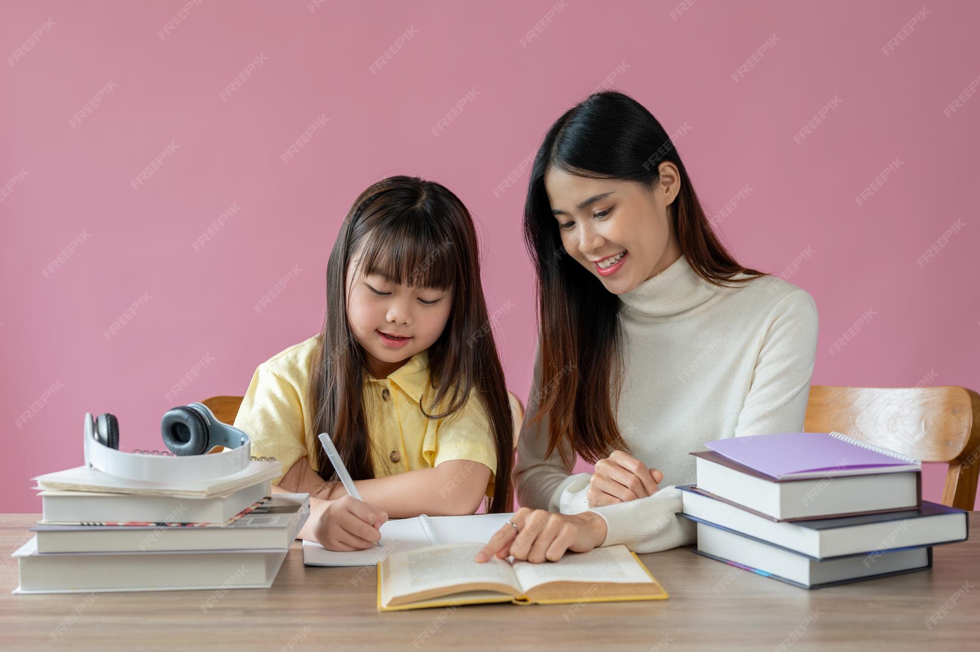 Premium Photo A Caring Asian Sister Or Private Teacher Is Teaching And Helping A Young Little