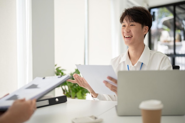 Premium Photo | A cheerful asian male office worker discusses work and ... Premium Photo | A cheerful asian male office worker discusses work and ...