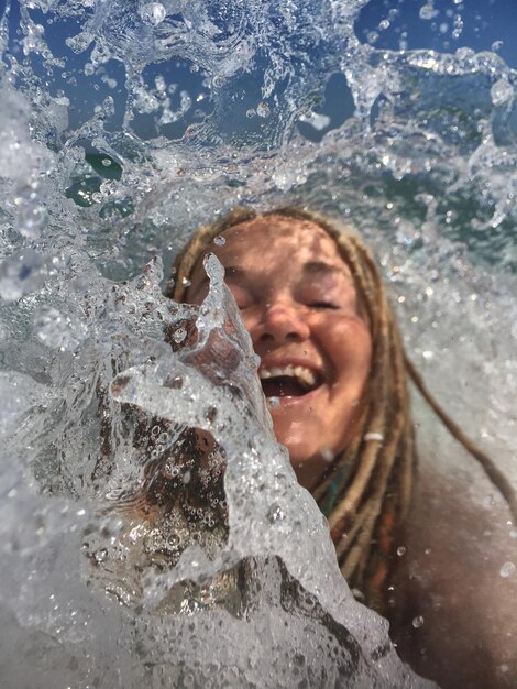 Premium Photo Cheerful Woman Splashing Sea Waves