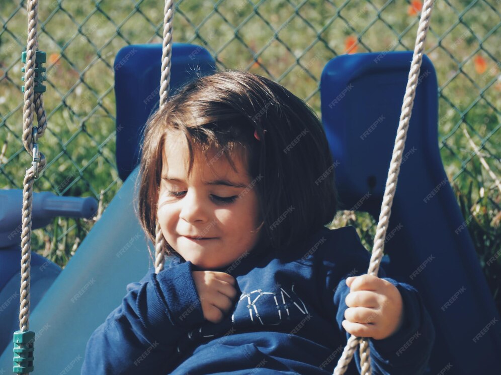 Premium Photo Close Up Of Cute Girl Sitting On Swing At Playground