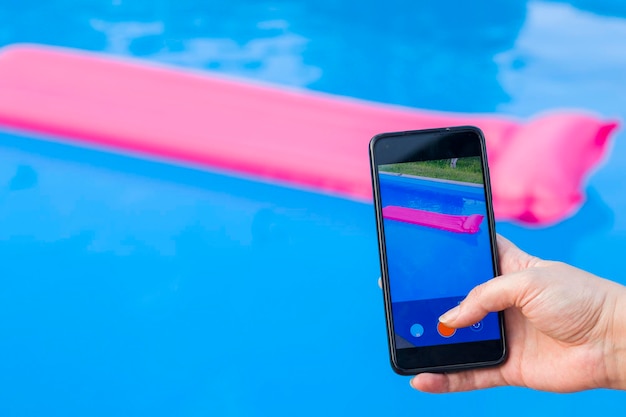 Premium Photo Close Up Of Hand Holding Mobile Phone In Swimming Pool