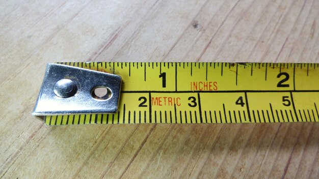 Premium Photo | Close-up of yellow tape measure on table Premium Photo | Close-up of yellow tape measure on table