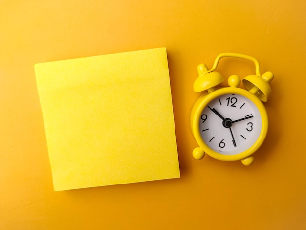 Premium Photo | Closeup yellow sticky note with alarm clock on a yellow ... Premium Photo | Closeup yellow sticky note with alarm clock on a yellow ...