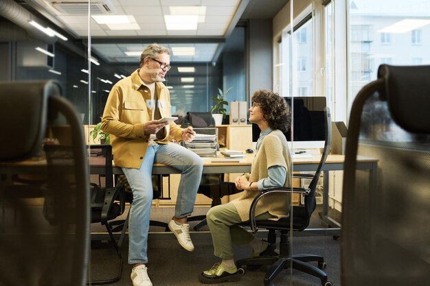 Premium Photo | Confident mature male manager talking to younger colleague Premium Photo | Confident mature male manager talking to younger colleague