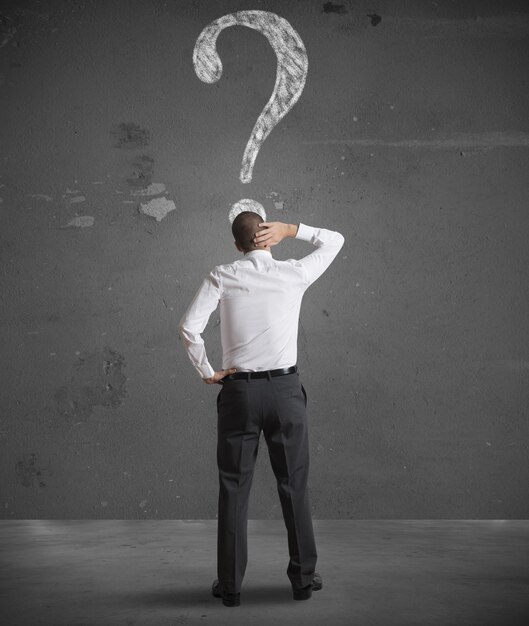 Premium Photo | Confused businessman looking at question mark Premium Photo | Confused businessman looking at question mark