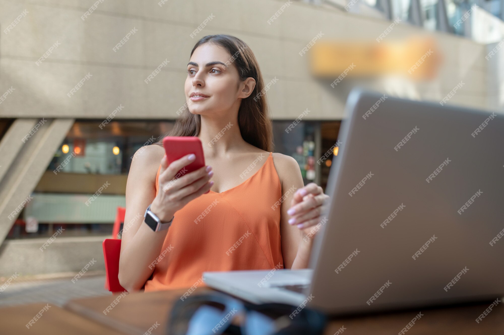 Premium Photo Dark Haired Pretty Woman Holding A Smartphone And Thinking