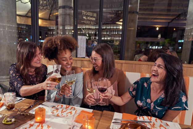 Premium Photo | Diverse positive friends clinking wineglasses Premium Photo | Diverse positive friends clinking wineglasses