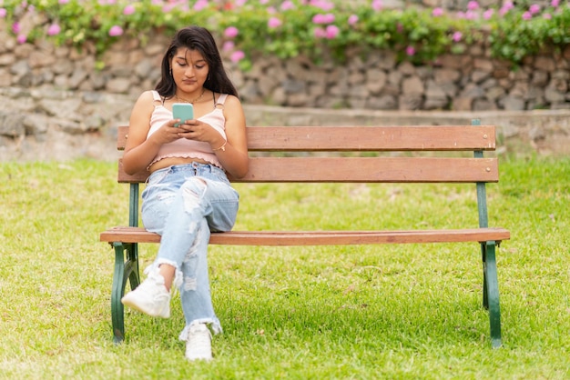 Premium Photo Girl Sitting On Park Bench Checking Cell Phone