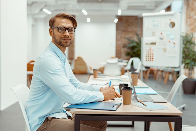 Premium Photo Guy In Glasses Sitting At A Table In A Coworking Space