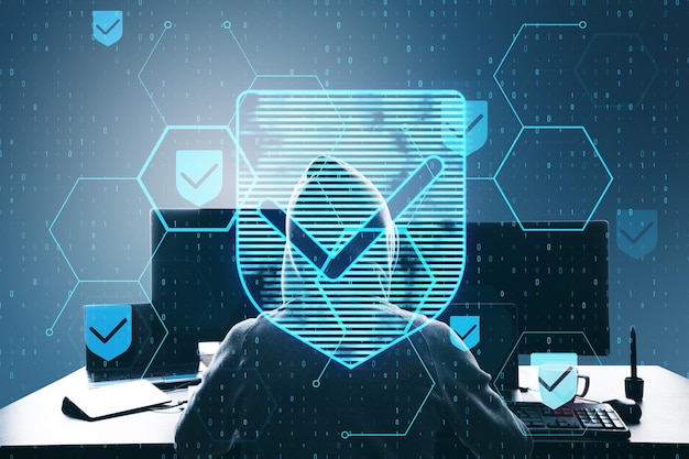 Premium Photo Hacker At Desktop Using Laptop With Glowing Hexagonal Shield Hologram With