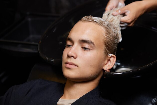 Premium Photo Hairstylist Hairdresser Washing Customer Hair Young Man