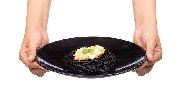 Premium Photo Hand Holding Black Spaghetti Carbonara On Plate