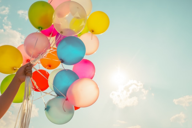Premium Photo | Hand holding multi colored balloons Premium Photo | Hand holding multi colored balloons