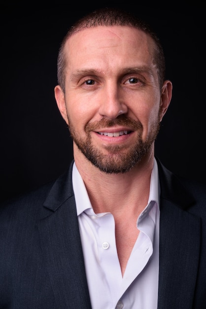 Premium Photo | Handsome bald bearded businessman in suit against black ... Premium Photo | Handsome bald bearded businessman in suit against black ...