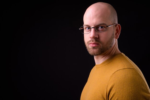 Premium Photo | Handsome bald bearded man against black space Premium Photo | Handsome bald bearded man against black space