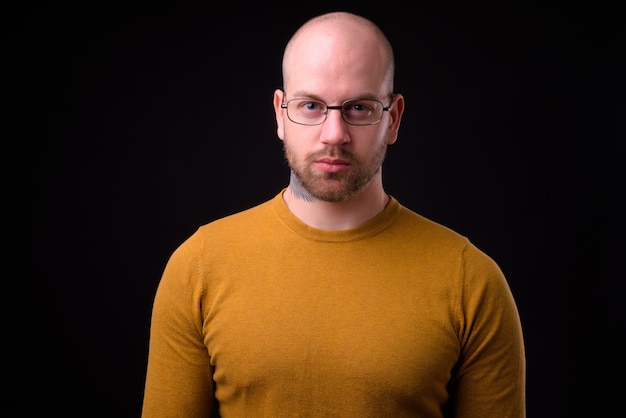 Premium Photo | Handsome bald bearded man against black space Premium Photo | Handsome bald bearded man against black space