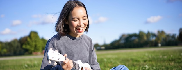 Premium Photo Happy People And Hobbies Smiling Asian Girl Playing