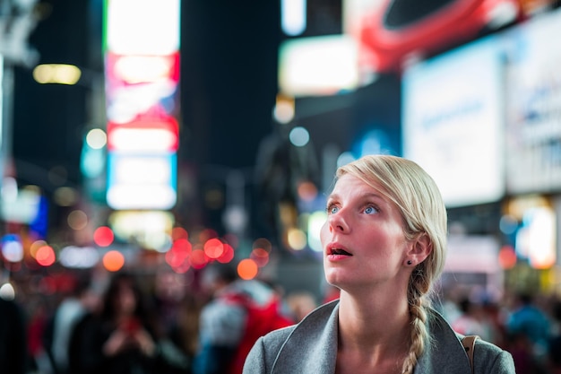 Premium Photo | Impressed woman in the middle of times square at night Premium Photo | Impressed woman in the middle of times square at night