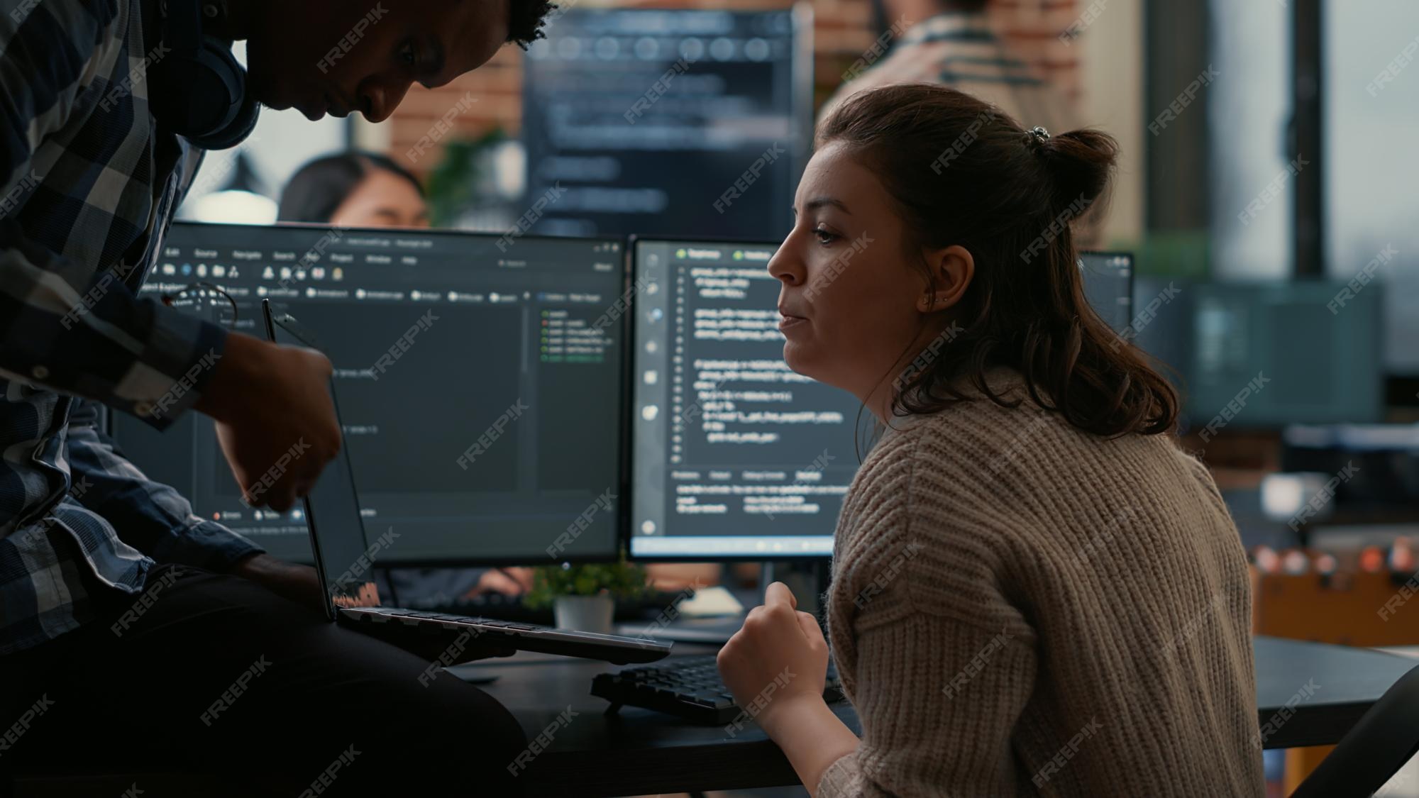 Premium Photo | Junior programer sitting down on desk showing laptop with source code to senior ...