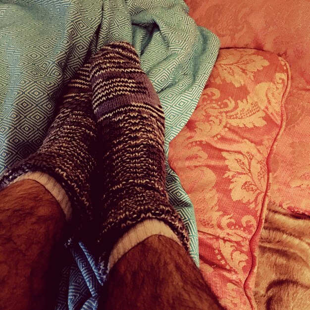 Premium Photo Low Section Of Man Wearing Socks On Bed