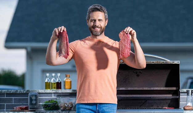 Premium Photo | Man cook grilling meat steak on bbq outdoor Premium Photo | Man cook grilling meat steak on bbq outdoor